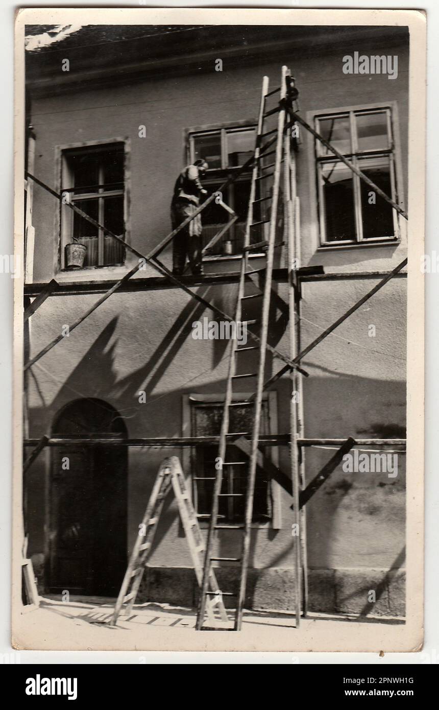 Vintage photo shows bricklayer works on wooden scaffolding Stock Photo ...