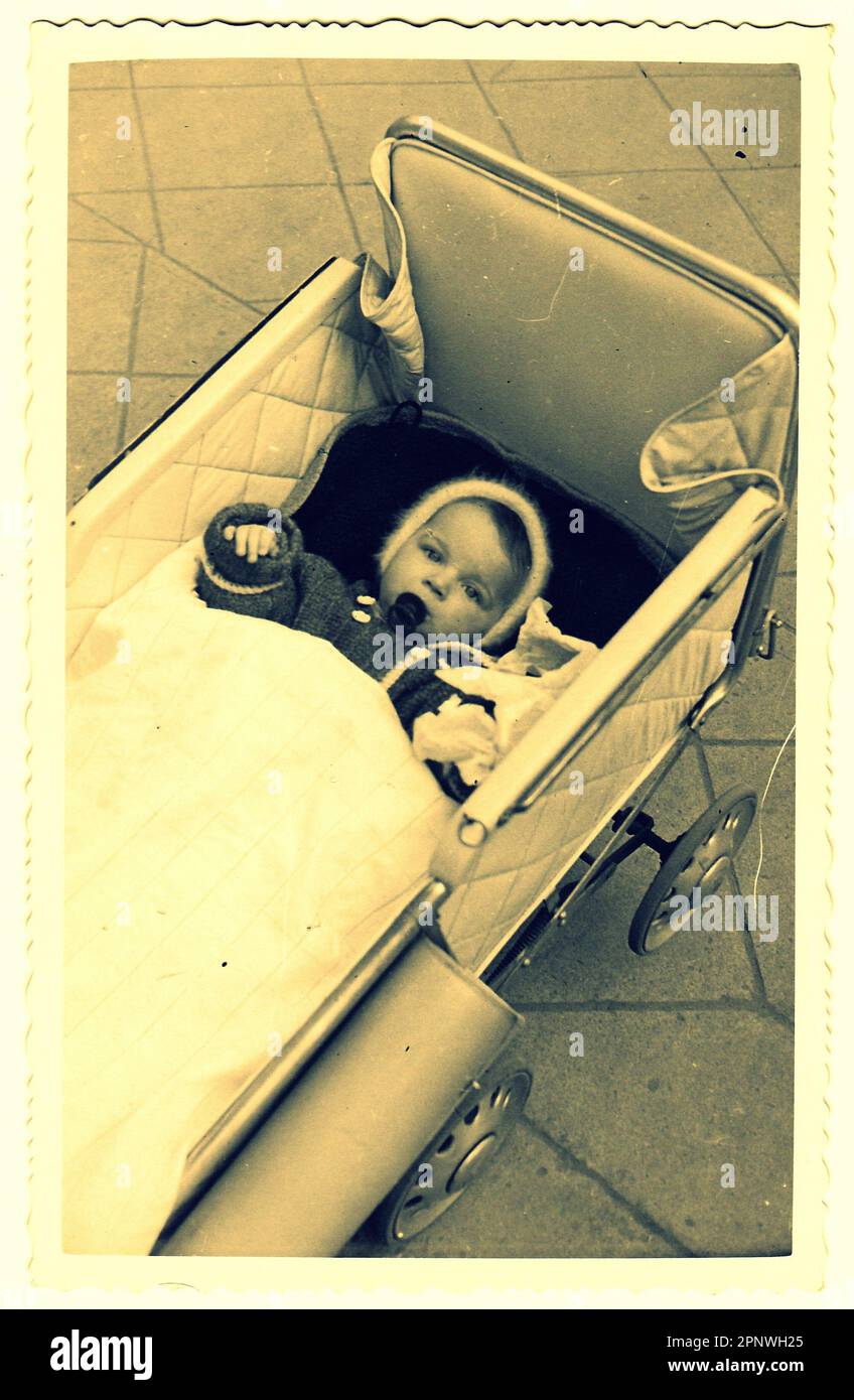 A vintage photo shows small baby girl in a pram - baby carriage Stock ...
