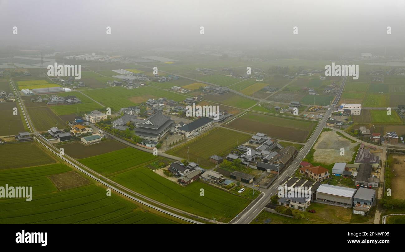 Aerial view of buildings and roads under low fog in Japanese ...