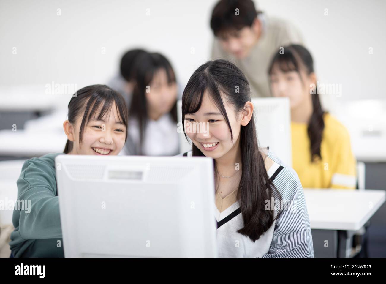 Students looking at a computer Stock Photo - Alamy