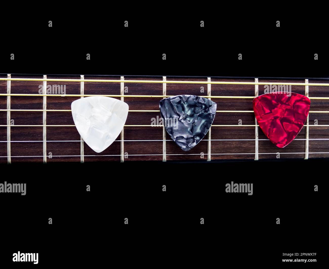 Three pick guitar on finger board background Stock Photo - Alamy