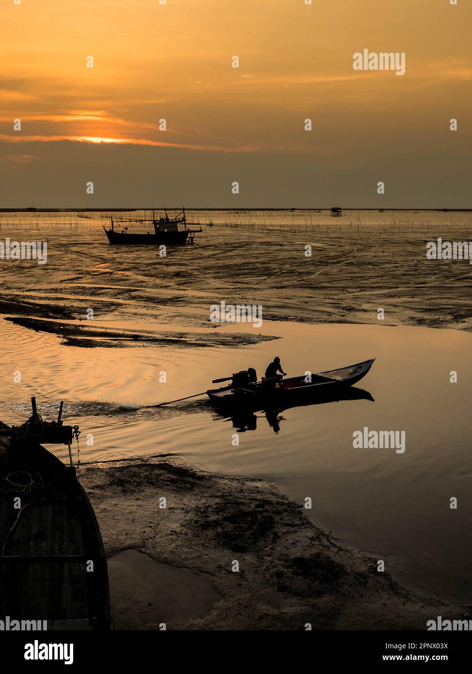 Fishing boat coming back home, sunset Stock Photo - Alamy