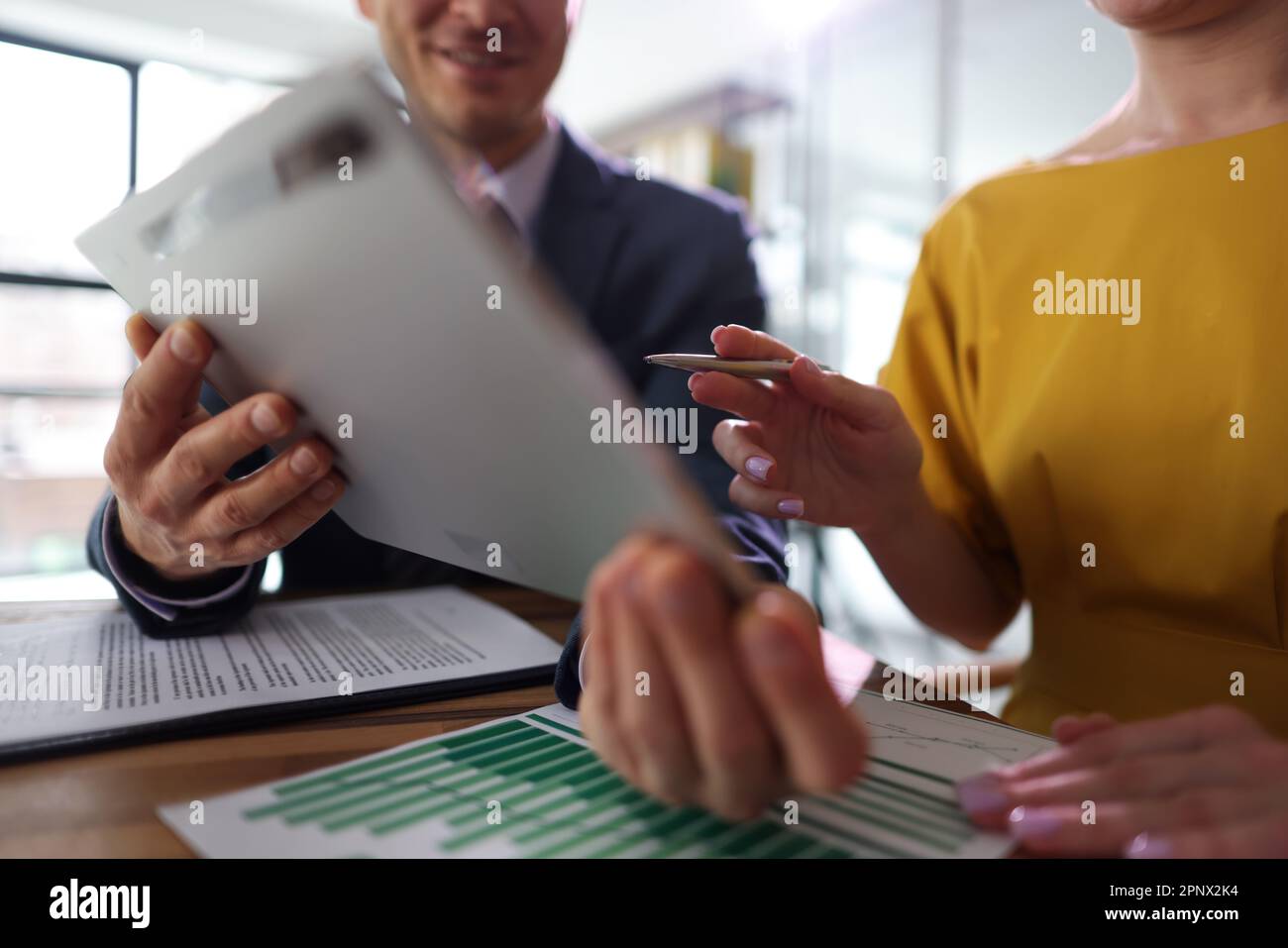 Man in business suit works in office with female client Stock Photo - Alamy