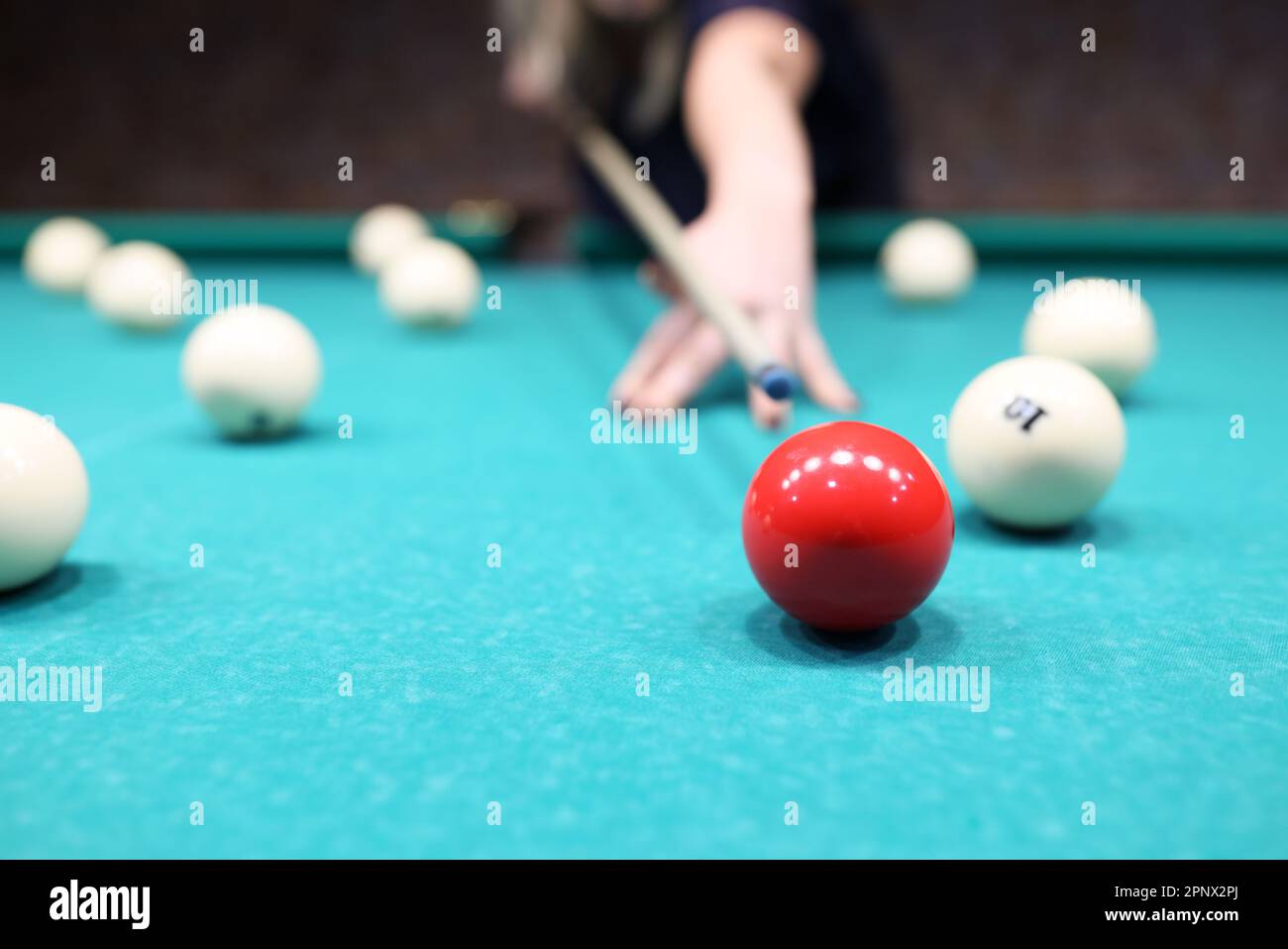 Female player ready to hit red ball on blue pool table Stock Photo - Alamy
