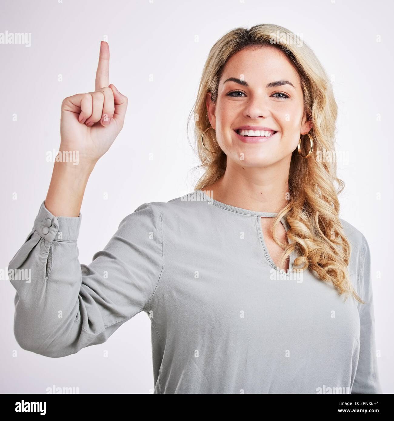 Woman, portrait and pointing finger up with a smile for hope, religion ...