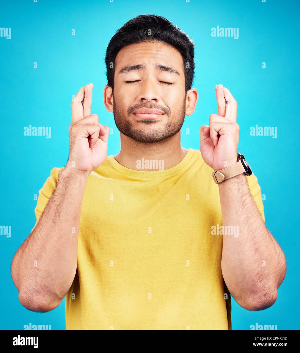 Hope, man and fingers crossed for miracle in studio isolated on a blue ...