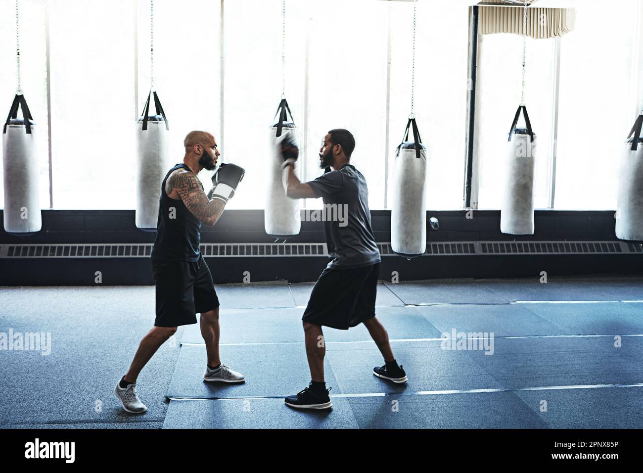 Box yourself fit. a male boxer practising his moves with his coach ...