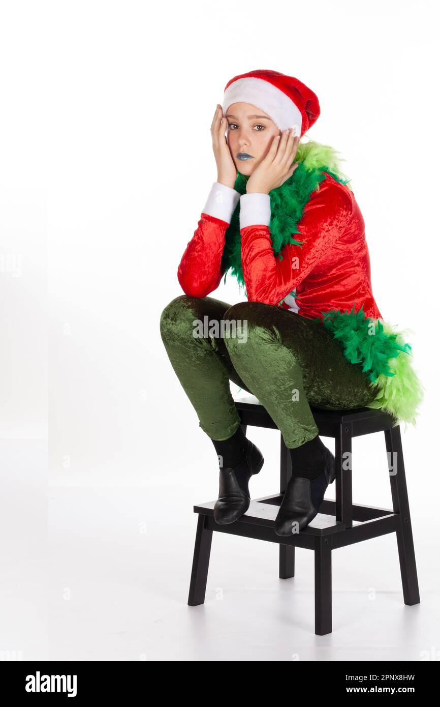 Sitting young girl wearing red santa clause hat like a grinch hands to ...