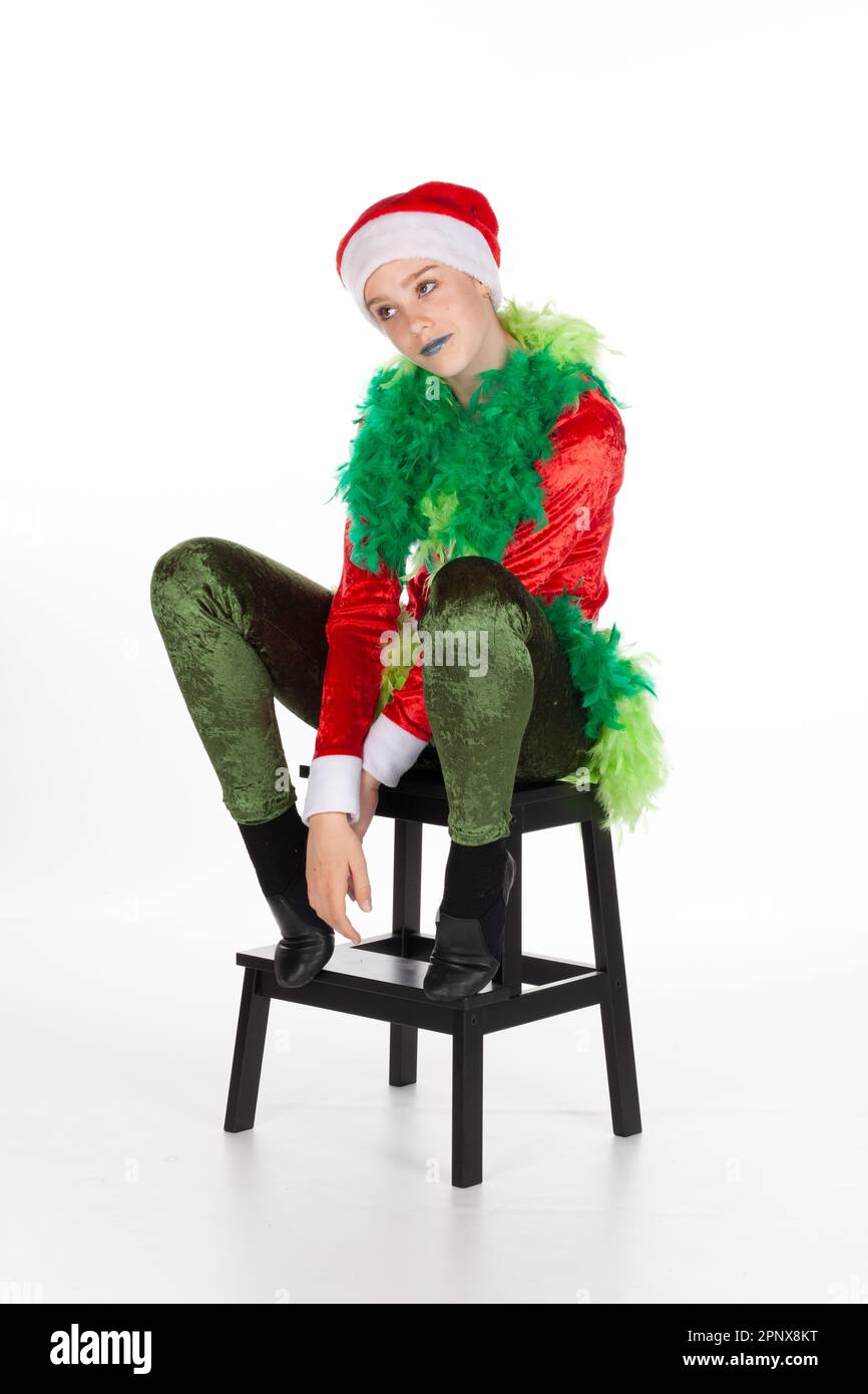 Sitting young girl wearing red santa clause hat like a grinch head ...