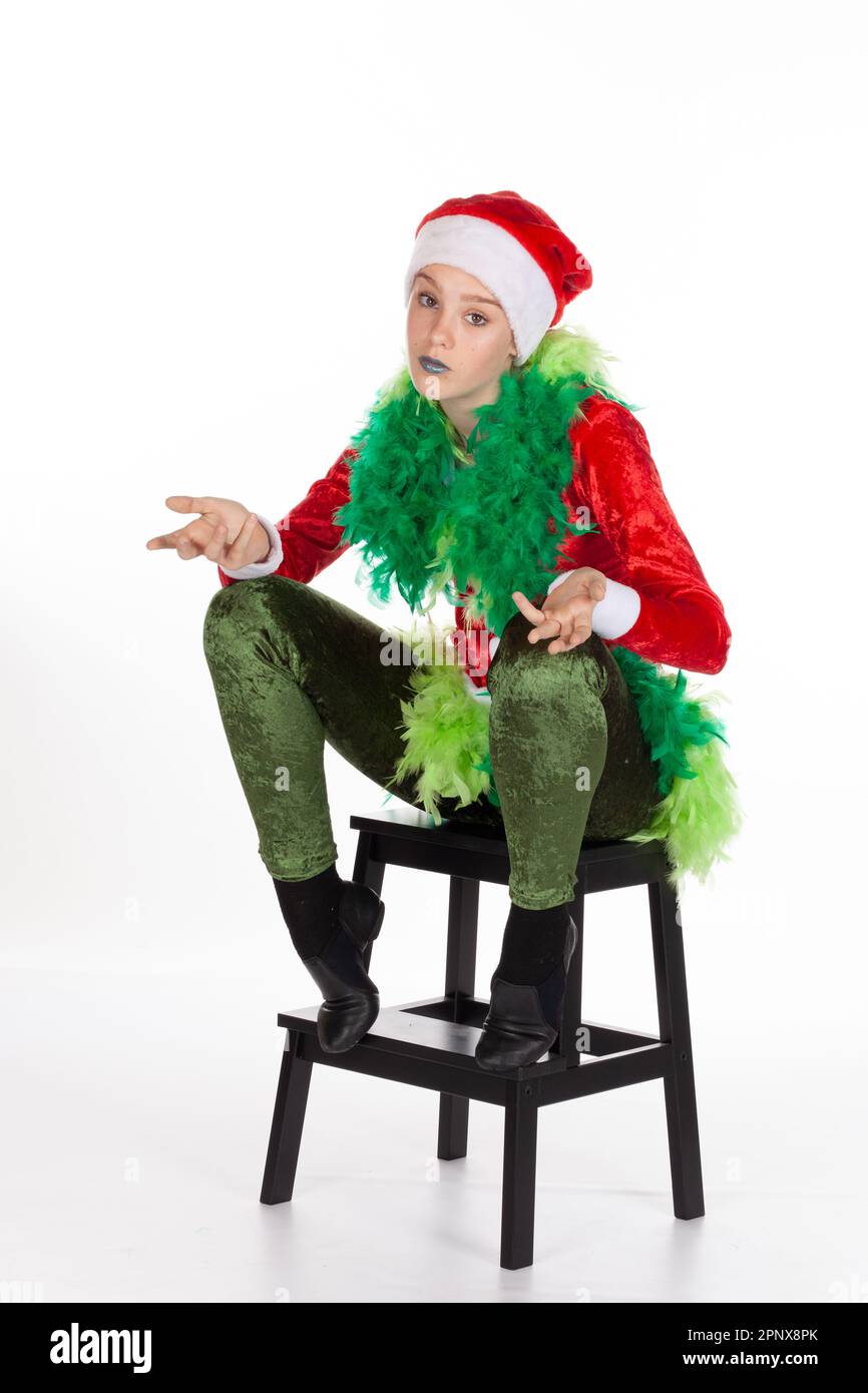 Sitting young girl wearing red santa clause hat like a grinch holding ...