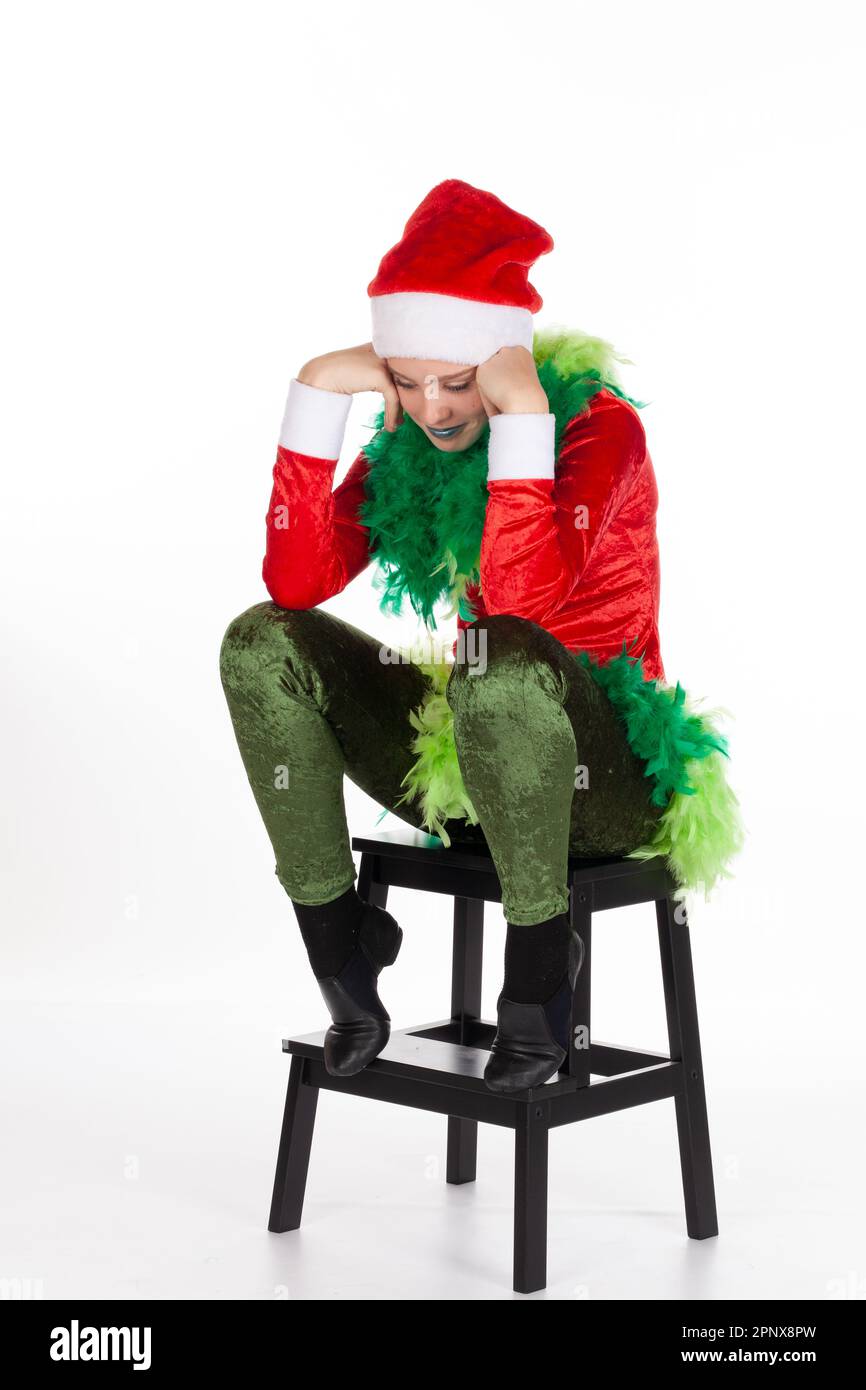 Sitting young girl wearing red santa clause hat like a grinch holding ...