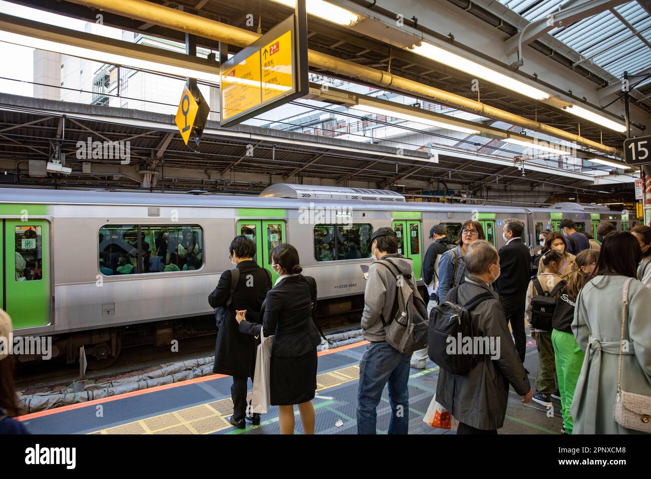 Tokyo train and commuters on underground platform waiting to travel ...