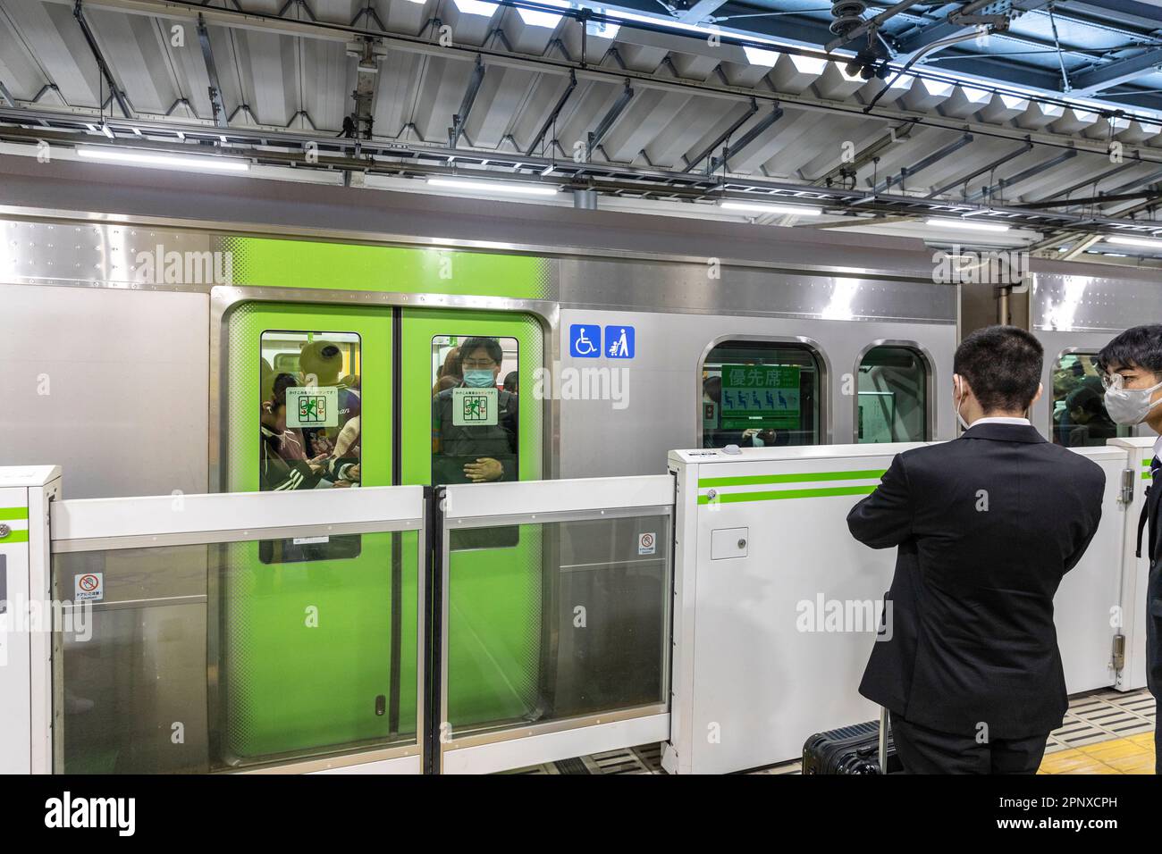 April 2023 Tokyo train carriage full of commuters and packed arrives at ...