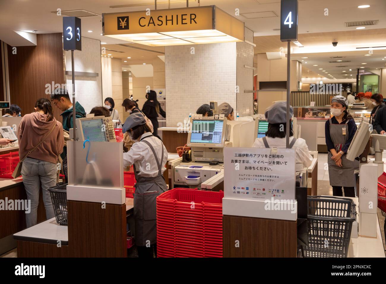 April 2023, customers pay for groceries at the cashier in a Tokyo food ...