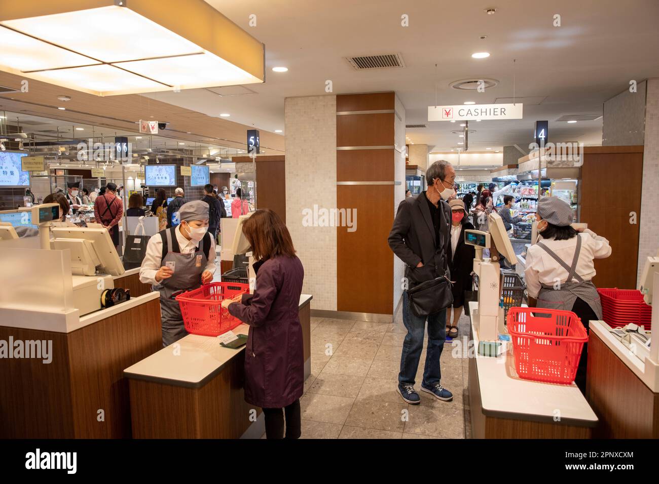 April 2023, customers pay for groceries at the cashier in a Tokyo food ...