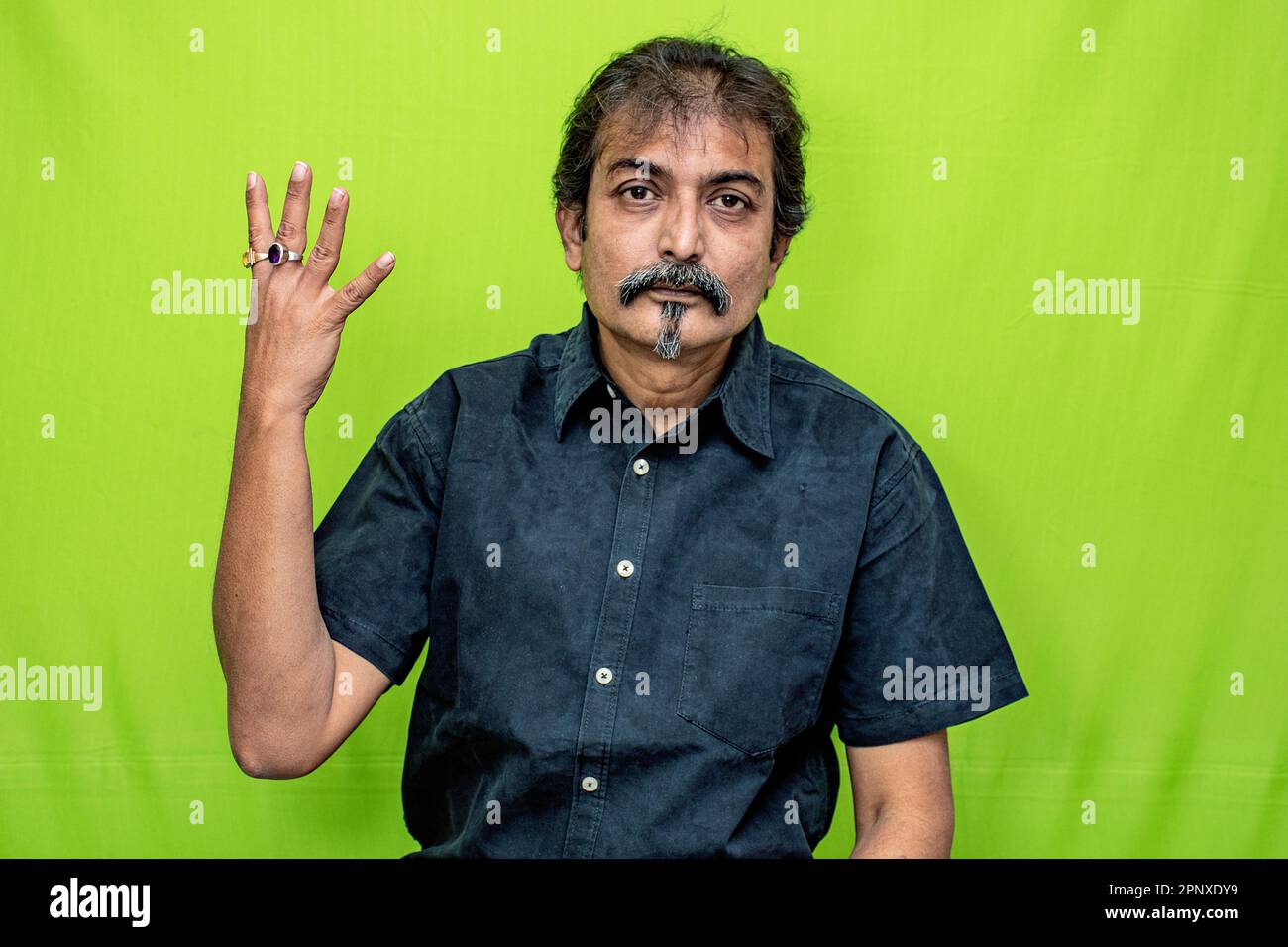 A smart gentleman in black shirt is showing 'four' with the fingers of ...