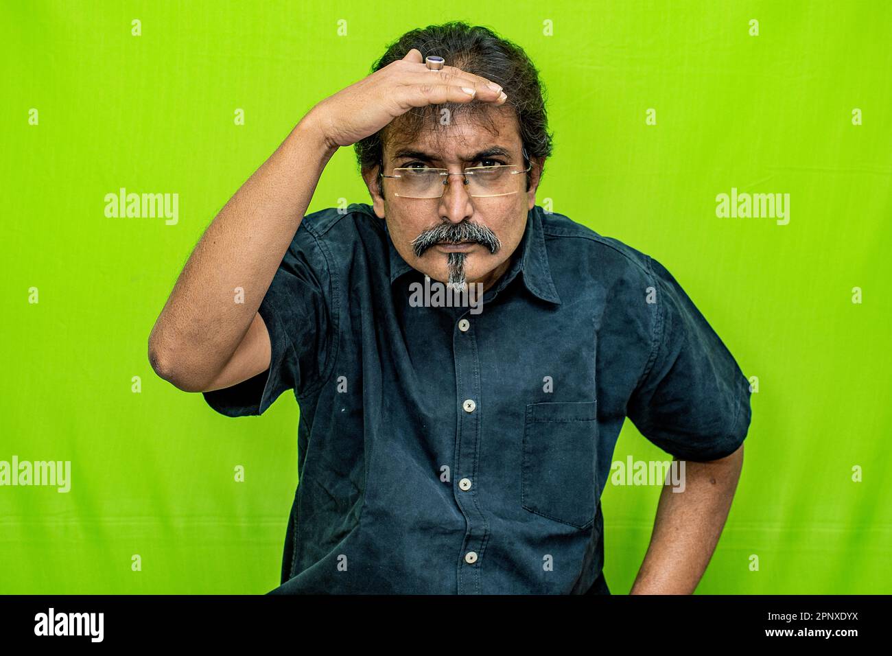 A smart corporate man in black shirt and spectacle, stands against ...