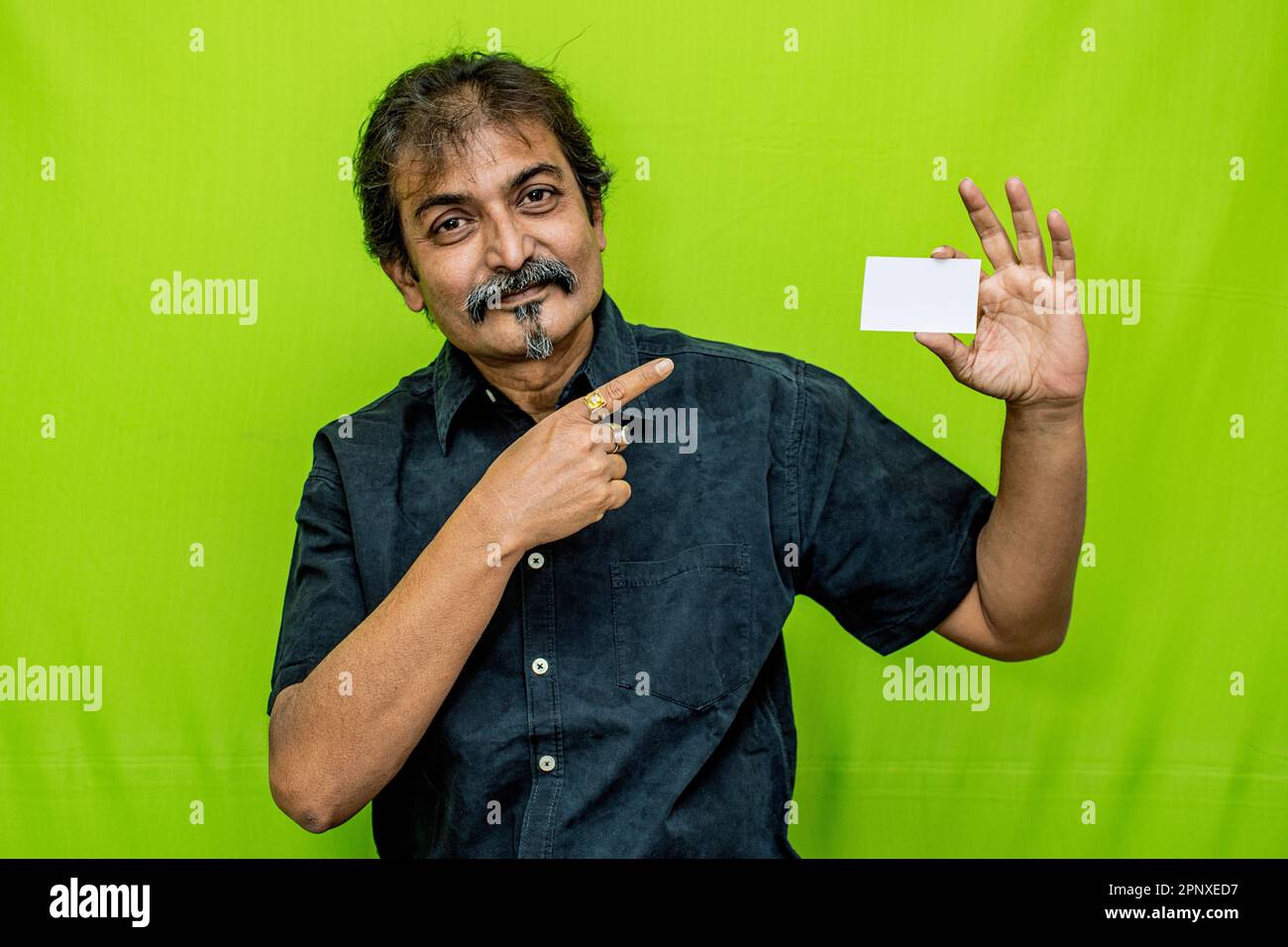 Corporate smart man in black shirt stands against a green screen with a ...