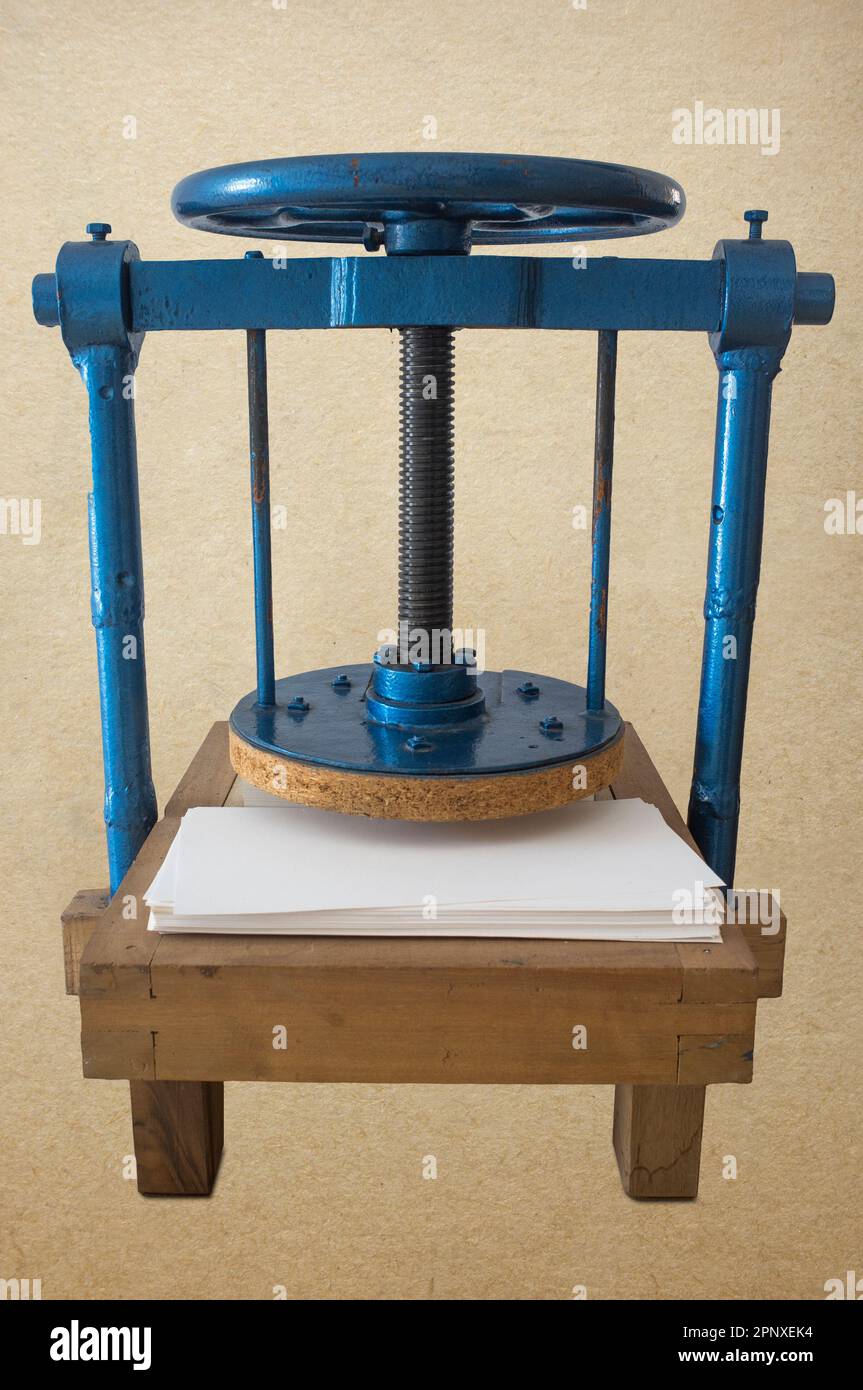 Screw bookbinding press over wooden stand. Isolated over old paper ...