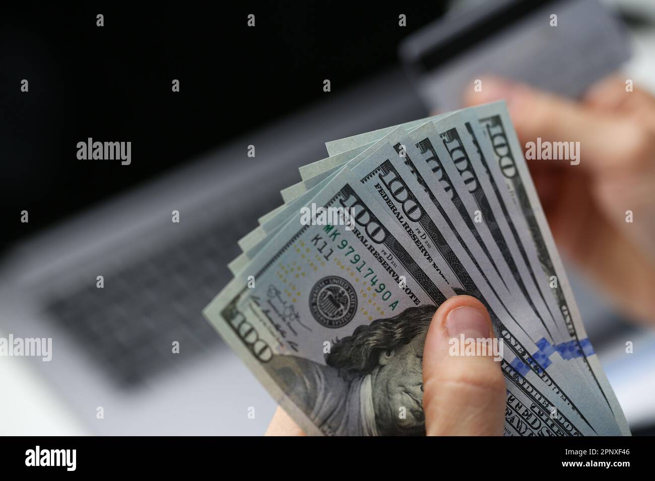 Hand holds paper currency and credit bank card Stock Photo - Alamy