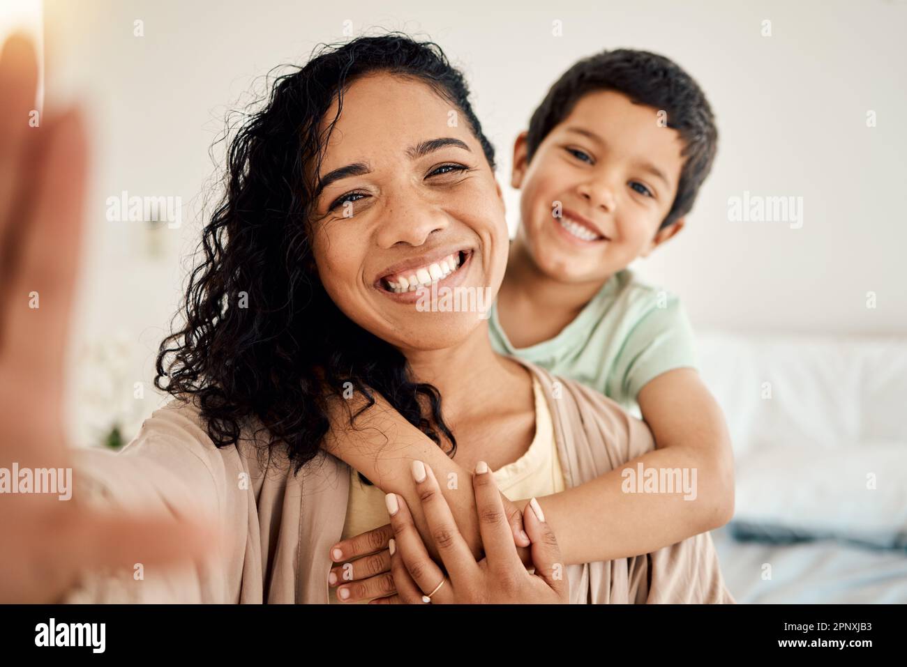 Smile, selfie and mother with child on a bed hug, love and bonding in their home together ...