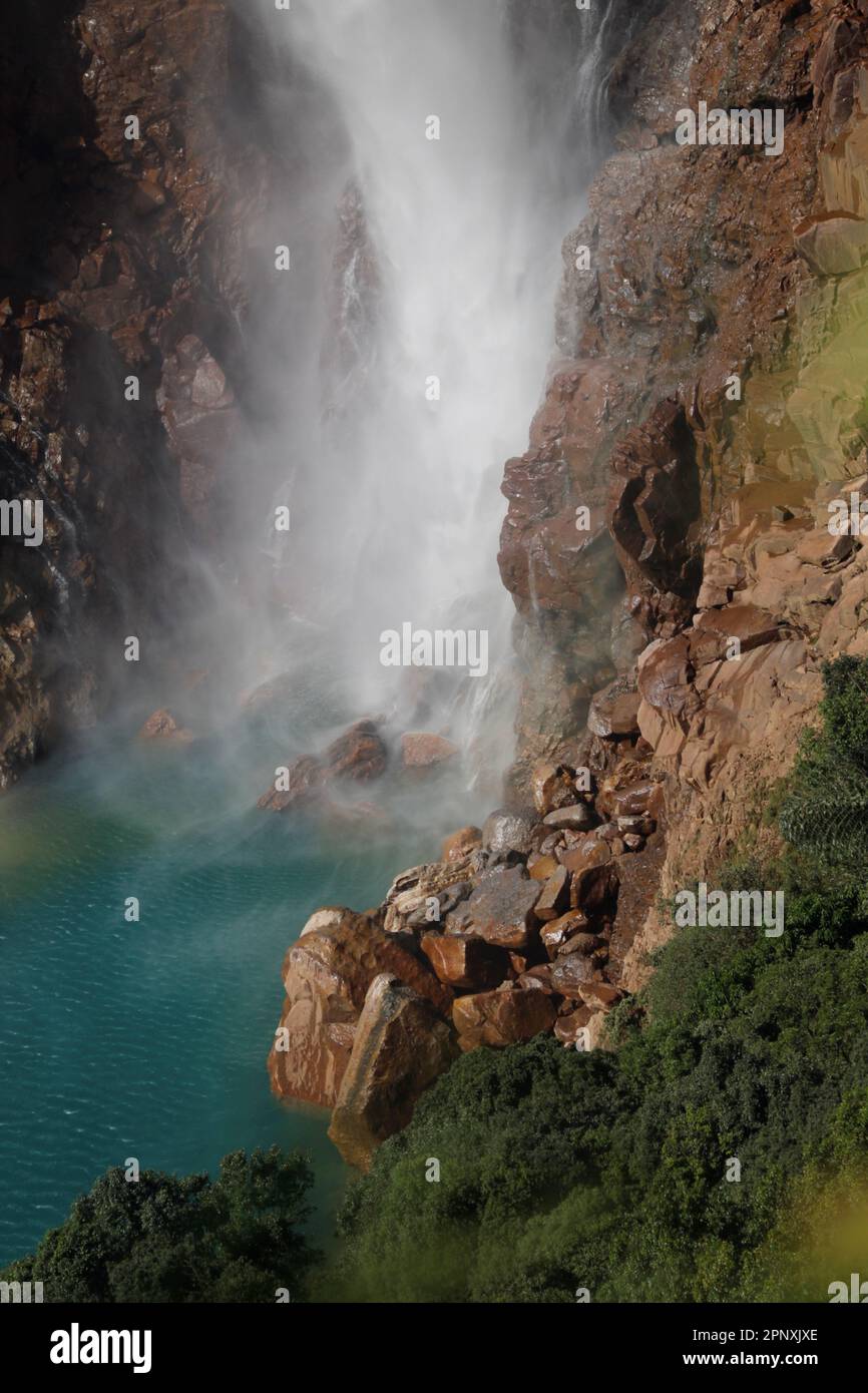 A majestic waterfall cascading down a sheer cliff face, releasing its ...