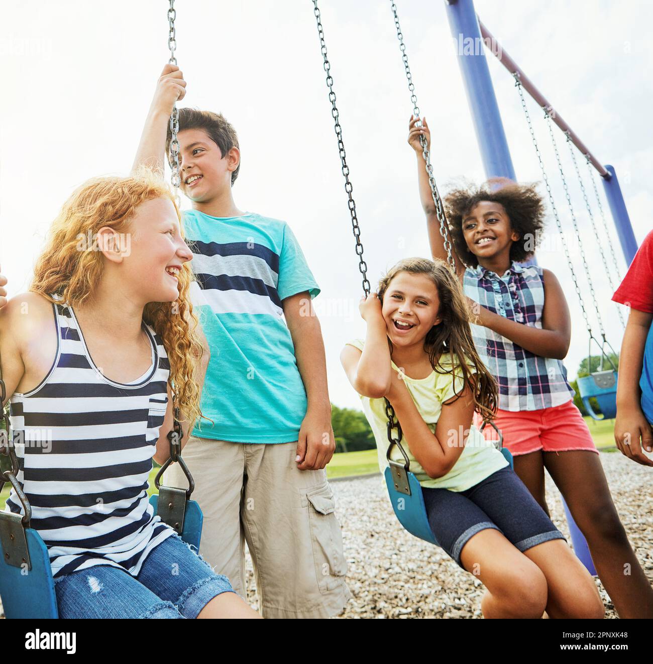 Lets see who goes higher. a group of young children playing together at ...