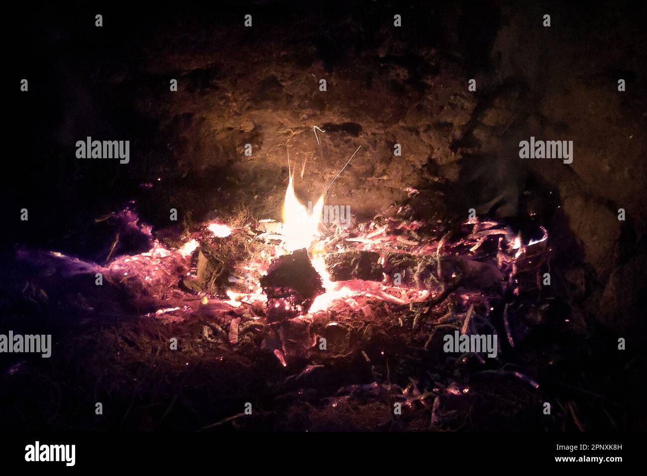 Close-up on a fire burning inside of a stone fireplace Stock Photo - Alamy