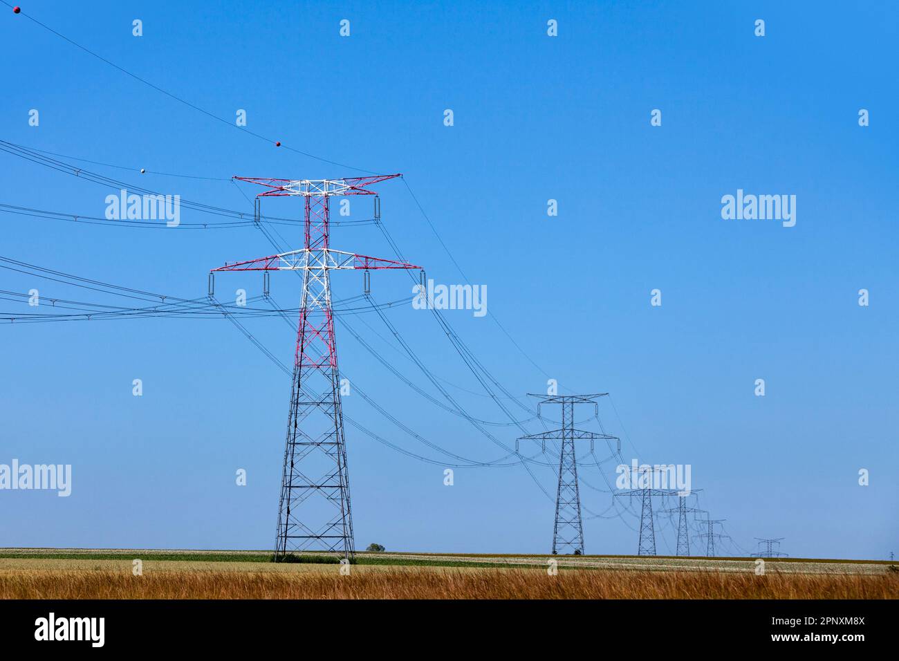 Electricity pylons in the french countryside under a clear blue sky ...