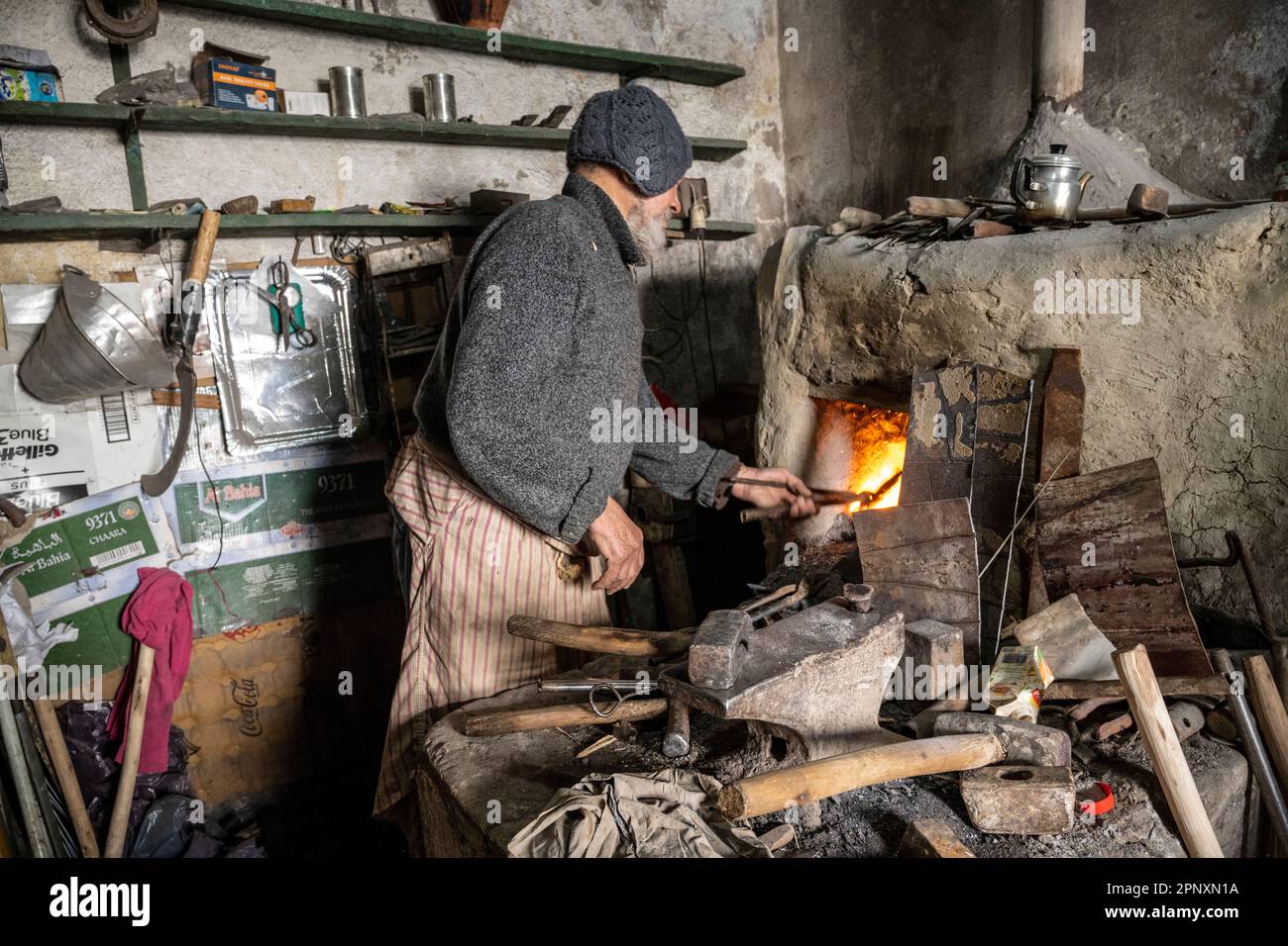 Traditional blacksmith working in the forge of his workshop Stock Photo ...