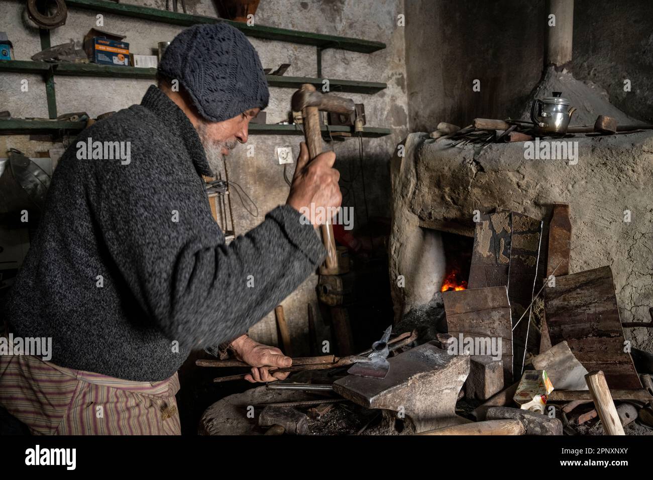 Traditional blacksmith working in the forge of his workshop Stock Photo ...