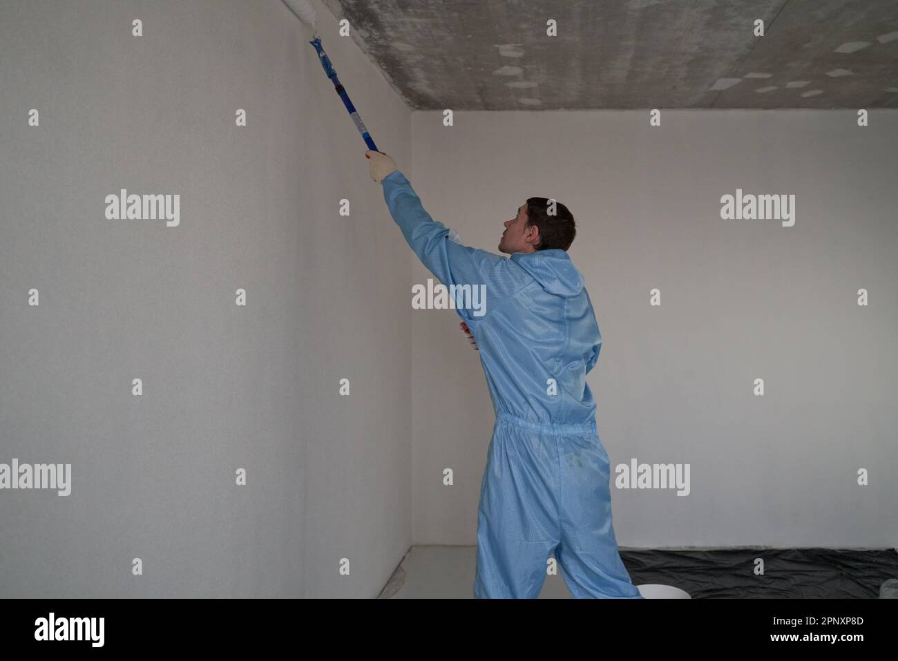 Man paints the ceiling with a roller. Concept of home makeover and ...