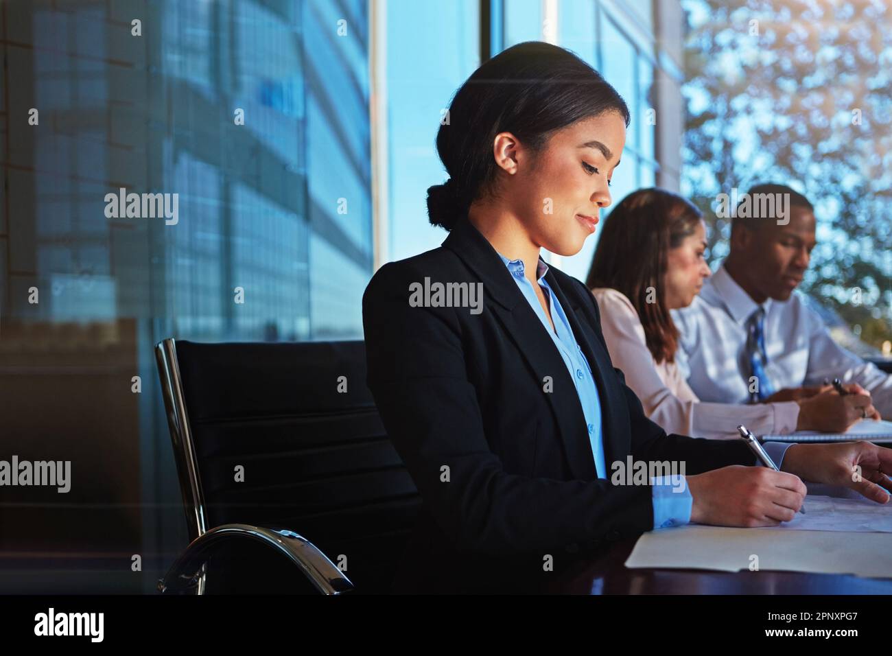 Focused on the tasks at hand. three young businesspeople meeting in the ...