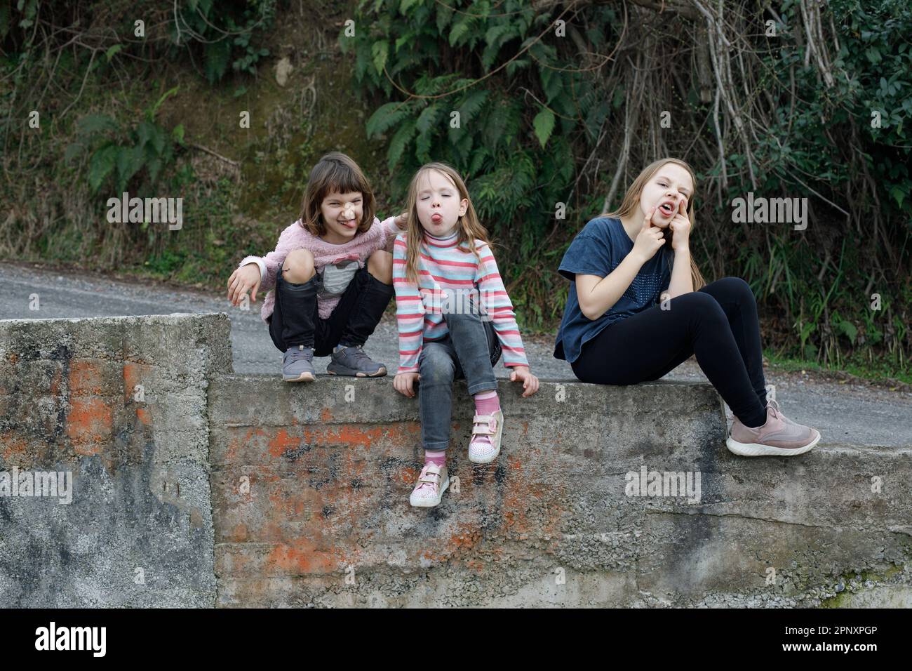 Grimacing kids. Outdoor portrait of three cute young girls Stock Photo ...