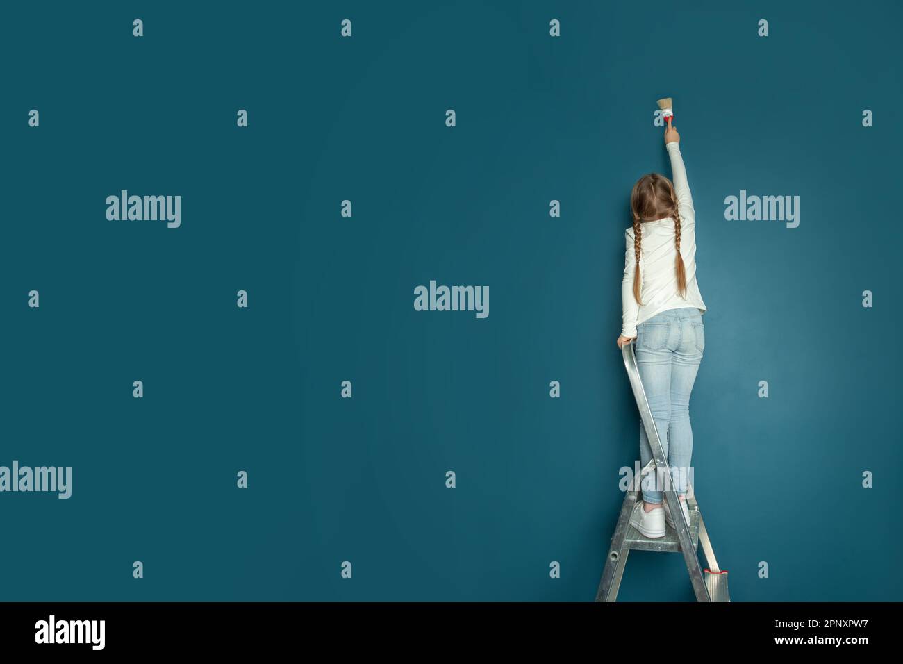 Child girl painting wall with brush and standing on the ladder Stock ...