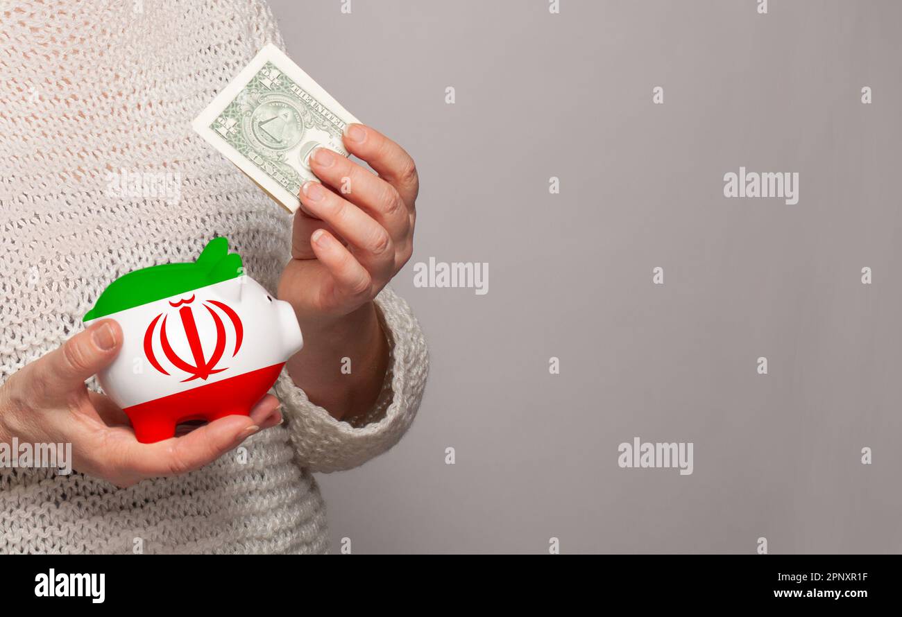 Flag of Iran on money bank in Irani woman hands. Dotations, pension ...
