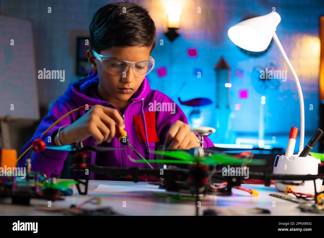 Intelligent serious indian kid busy making drone connections by ...