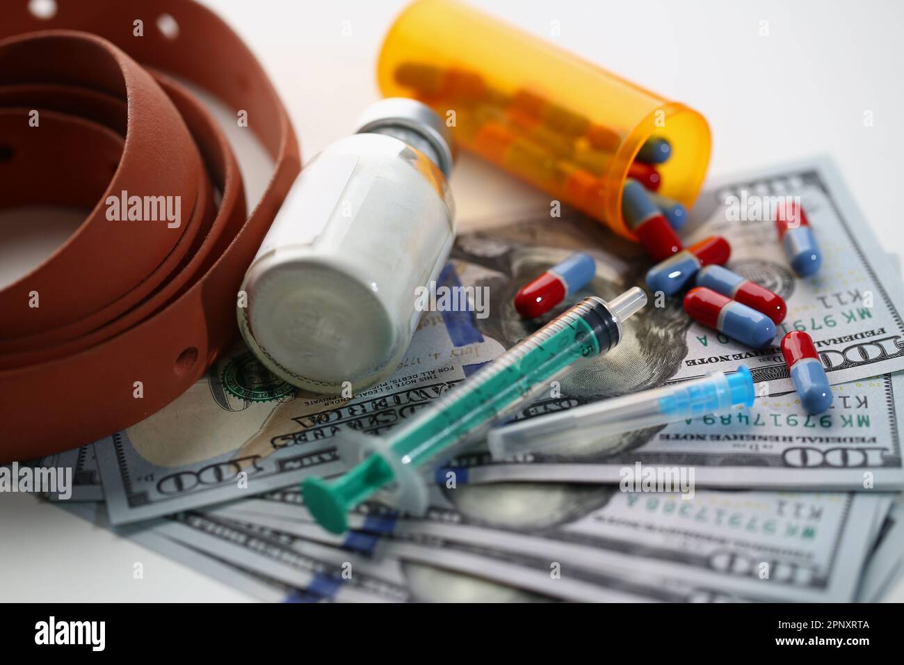 Medical syringe with white cocaine powder and medical pills on dollar ...