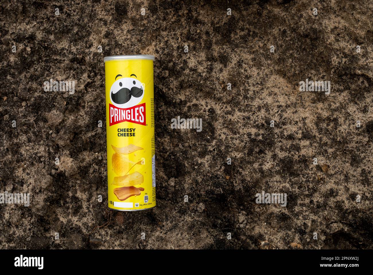 Pringles chips with cheese in yellow packaging are taken in a private ...