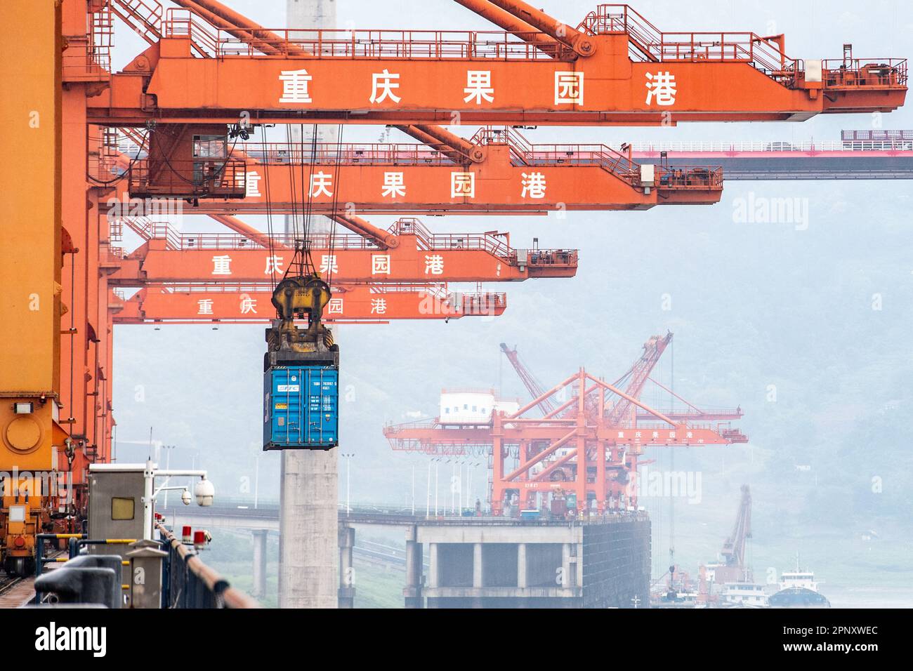 Chongqing. 20th Apr, 2023. A crane lifts a shipping container at ...