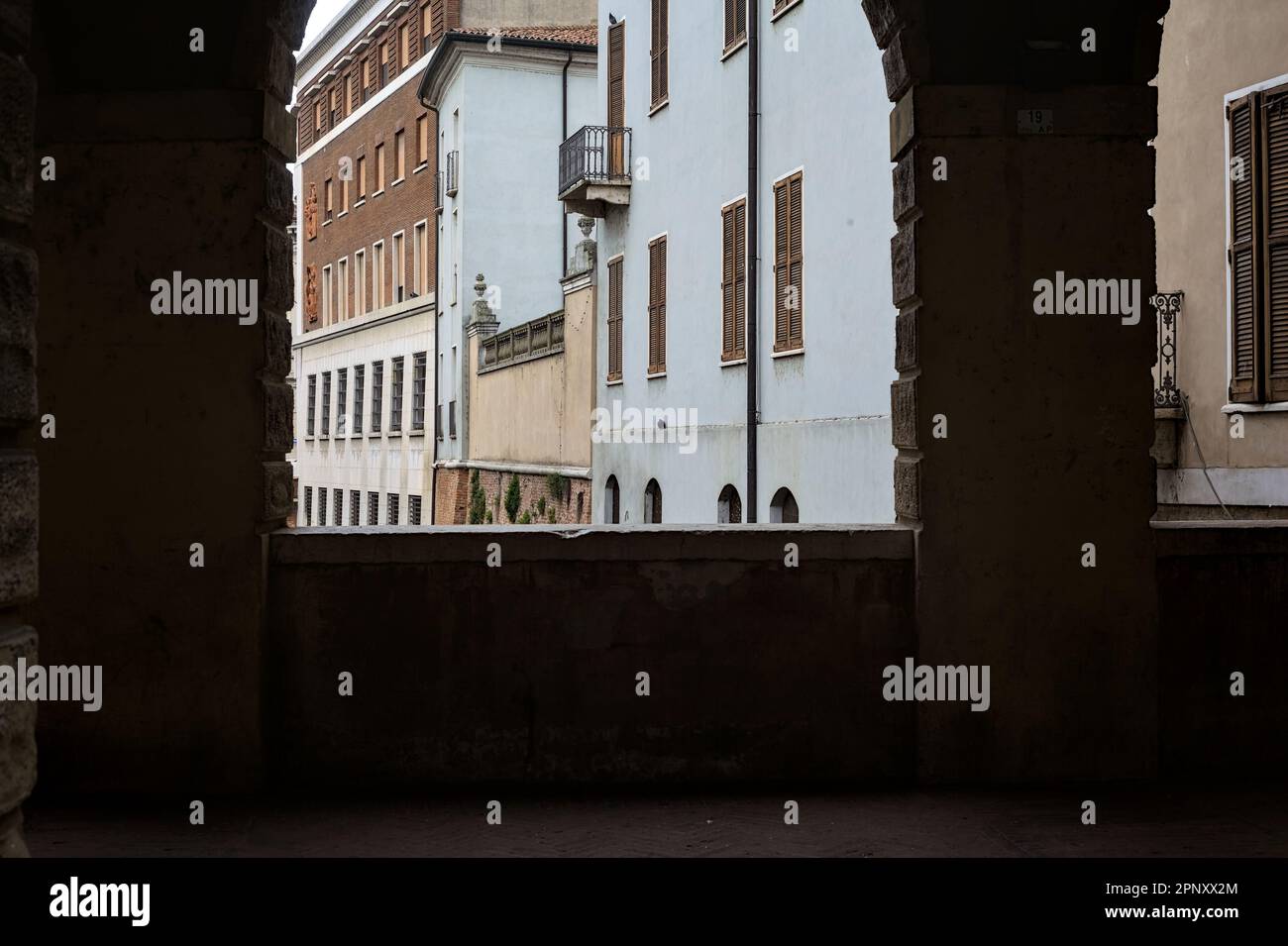 Channel bordered by a building framed by arches of a covered porchway ...