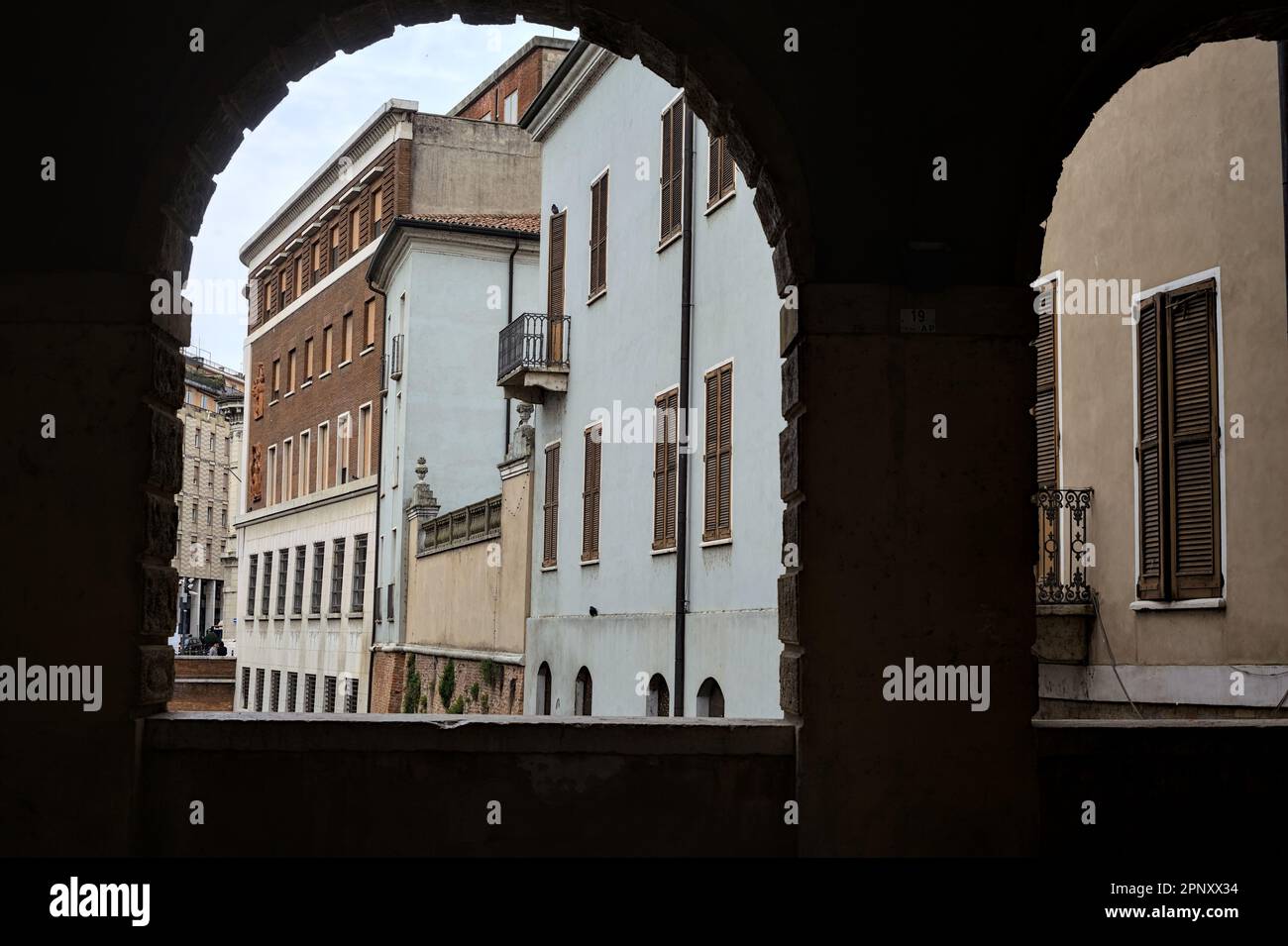Channel bordered by a building framed by arches of a covered porchway ...