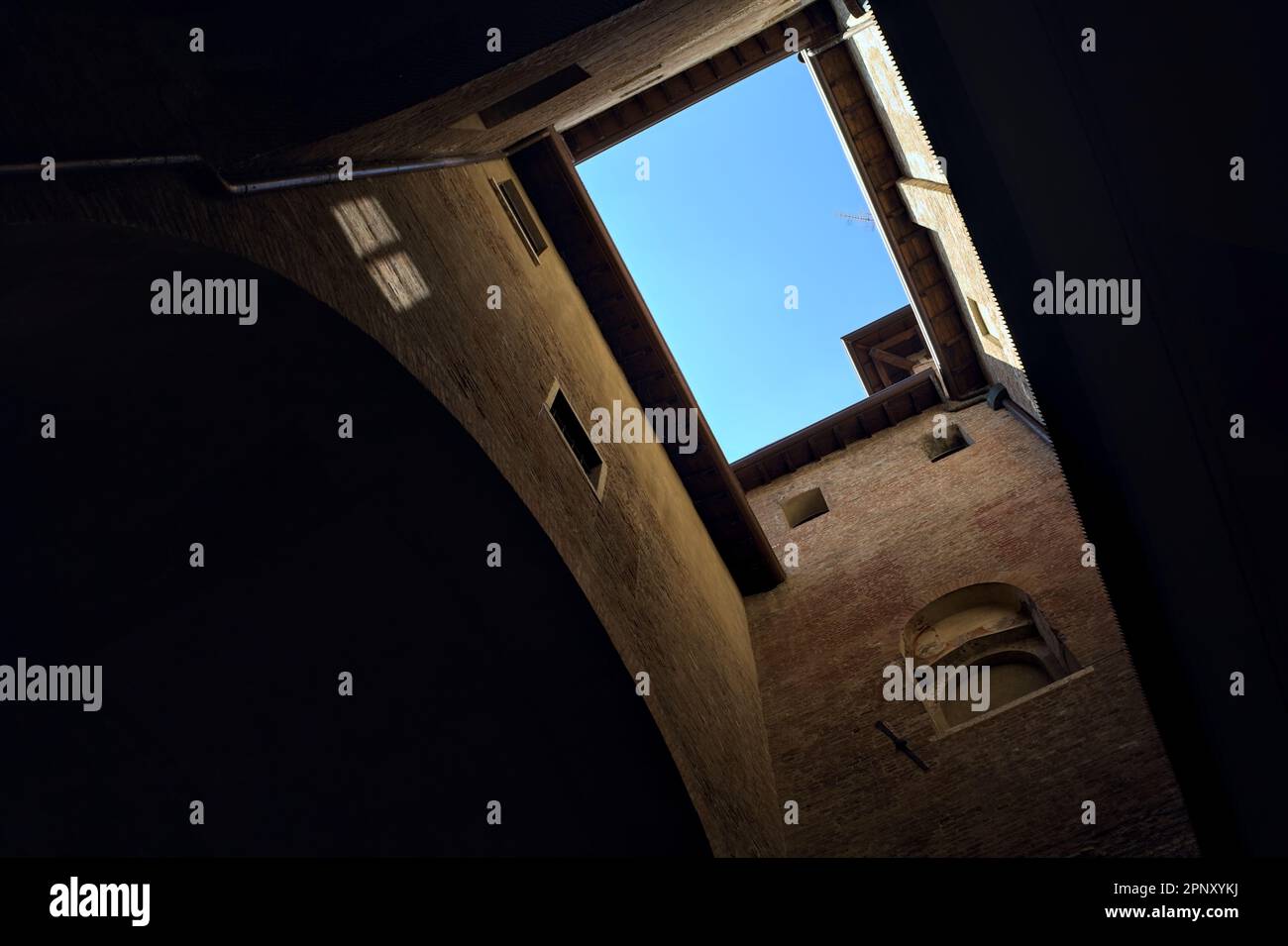Opening between buildings in a covered alley with a clear sky above ...