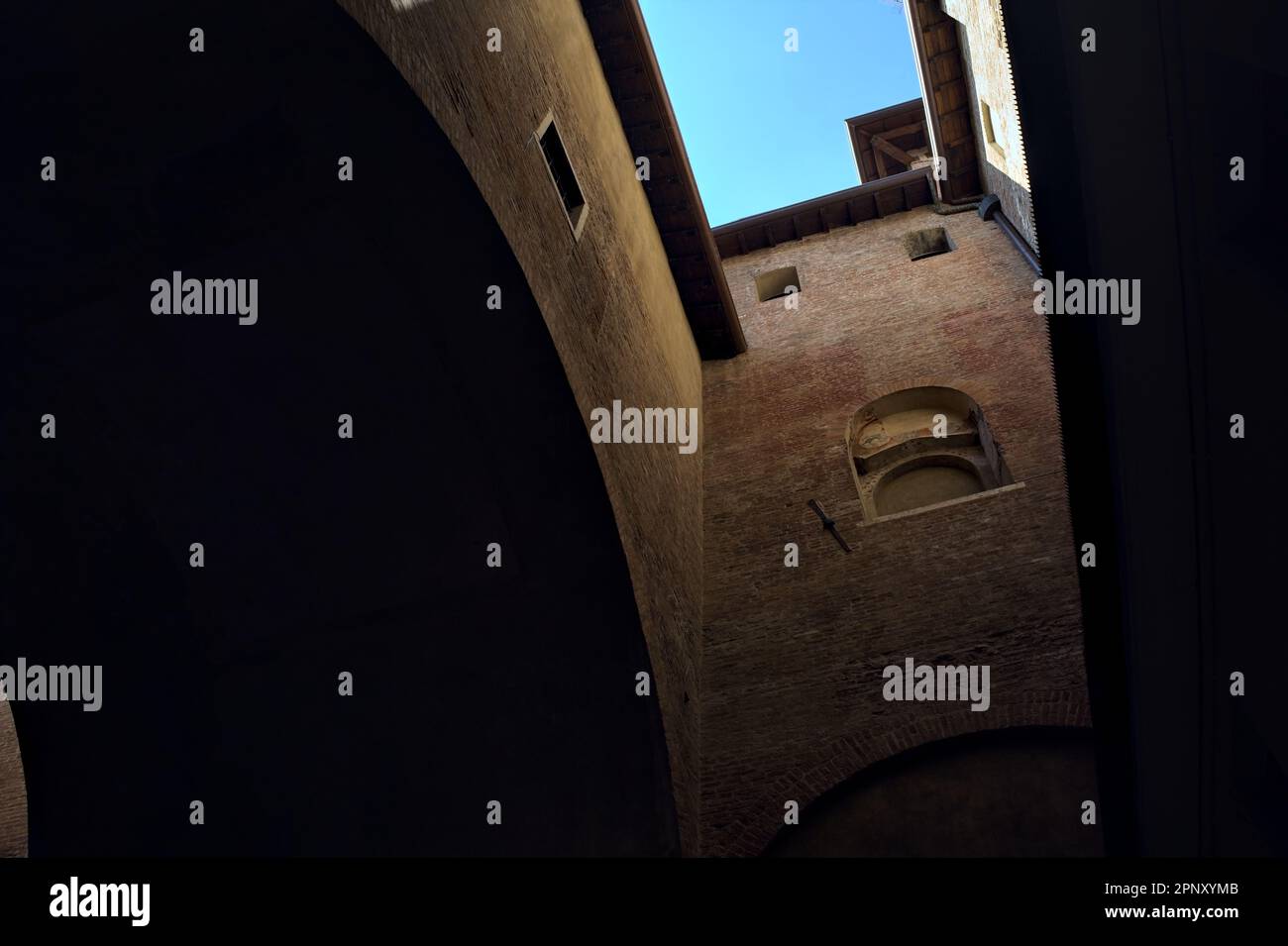 Opening between buildings in a covered alley with a clear sky above ...
