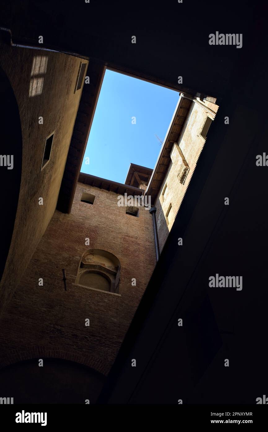 Opening between buildings in a covered alley with a clear sky above ...