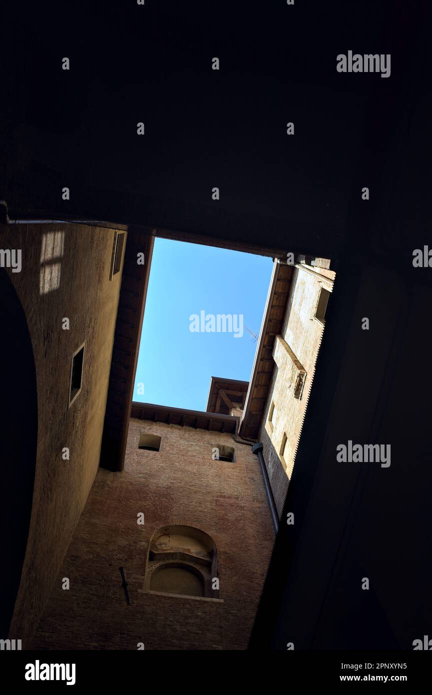 Opening between buildings in a covered alley with a clear sky above ...