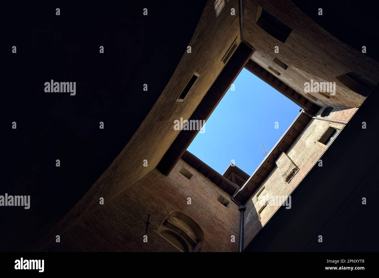 Opening between buildings in a covered alley with a clear sky above ...