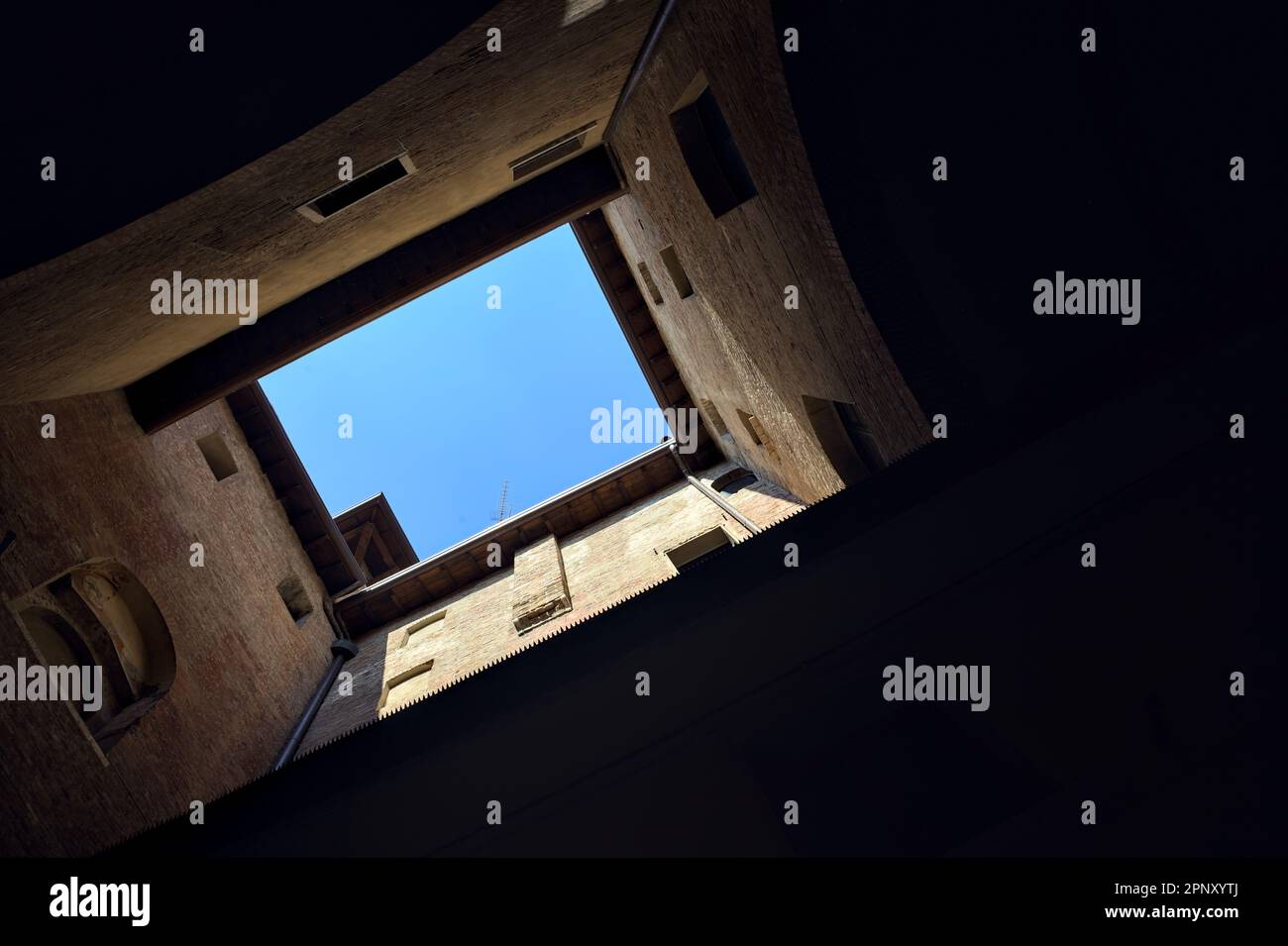 Opening between buildings in a covered alley with a clear sky above ...