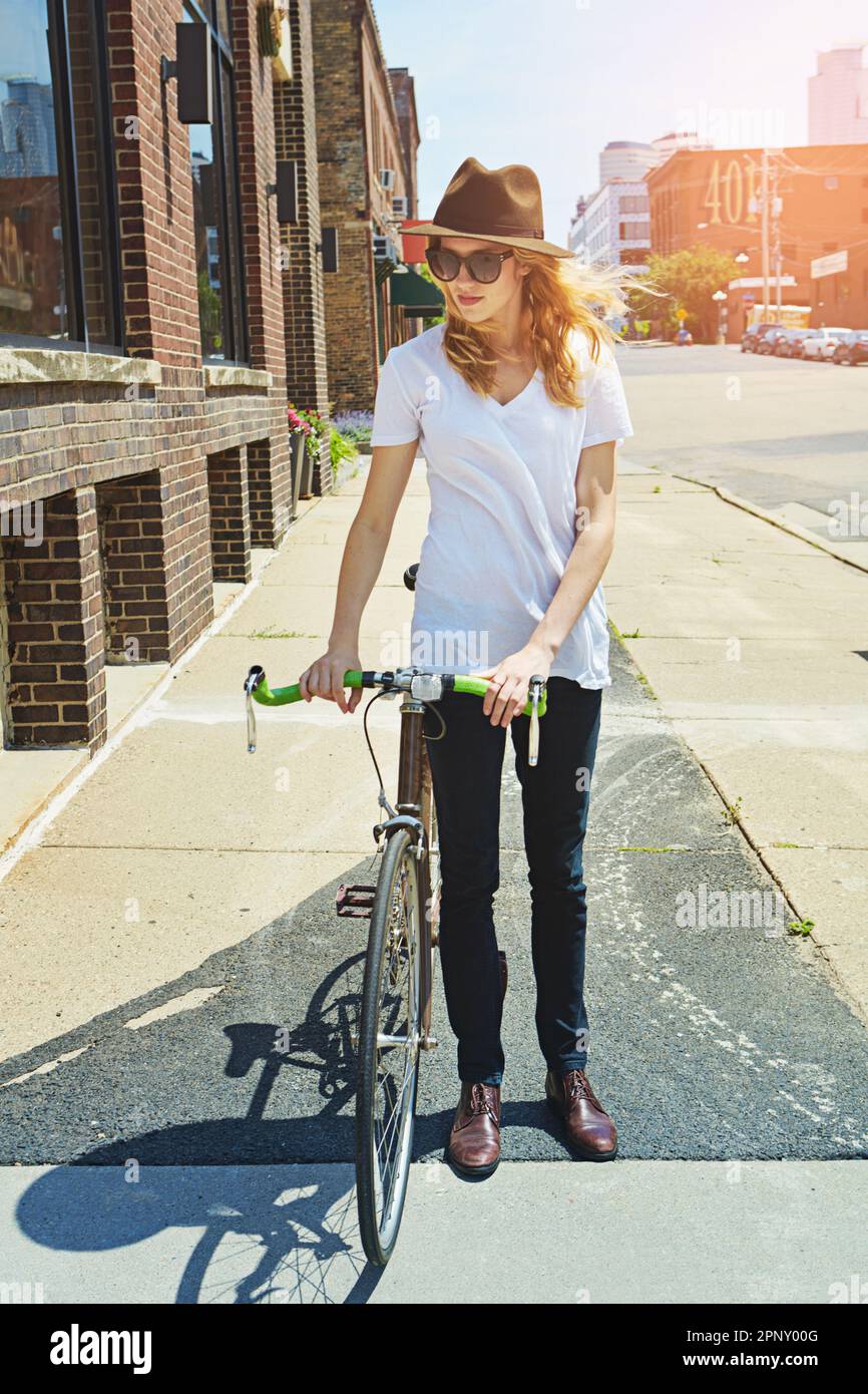 Take a ride on the urban side. a young woman riding a bike in the city ...