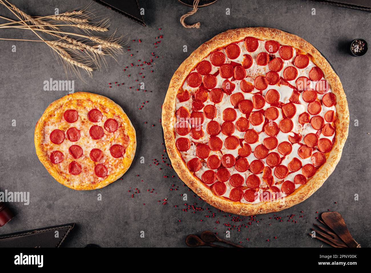 Side view on small and giant pepperoni pizzas Stock Photo - Alamy